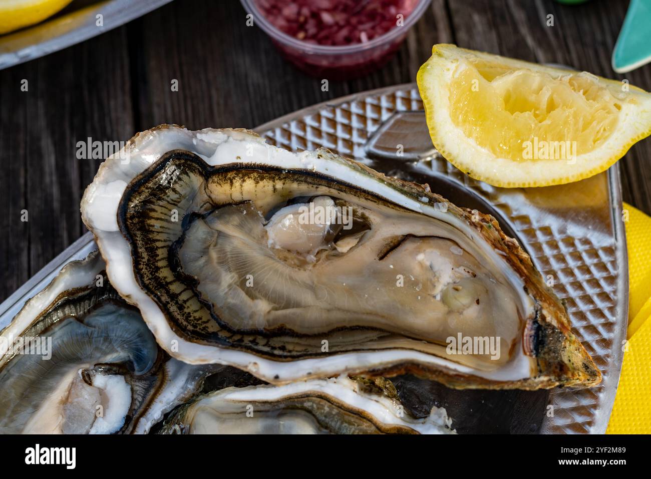 Plate with fresh live raw oysters seashells with citron, bread, butter ...