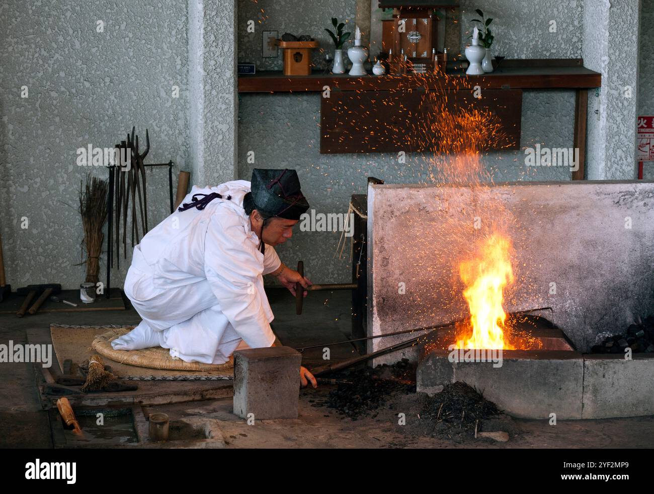 Traditional Japanese sword maker preparing red hot iron with coals in ...