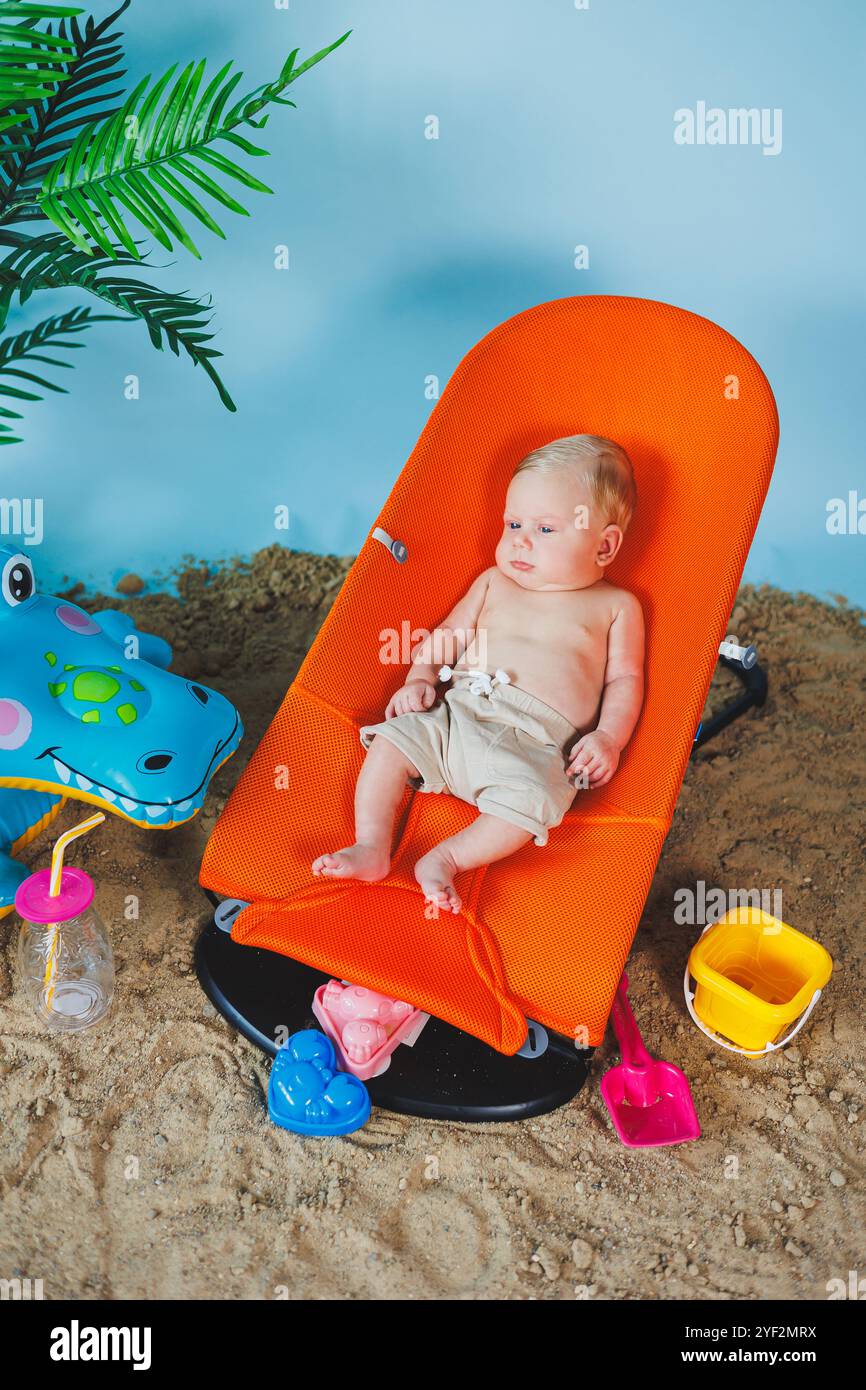 A baby is lying on a recliner chair for babies. Children's recreation ...