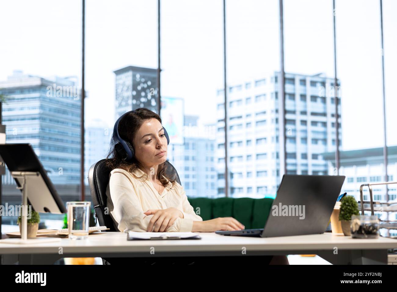 Young entrepreneur listening to a podcast while she solves daily ...