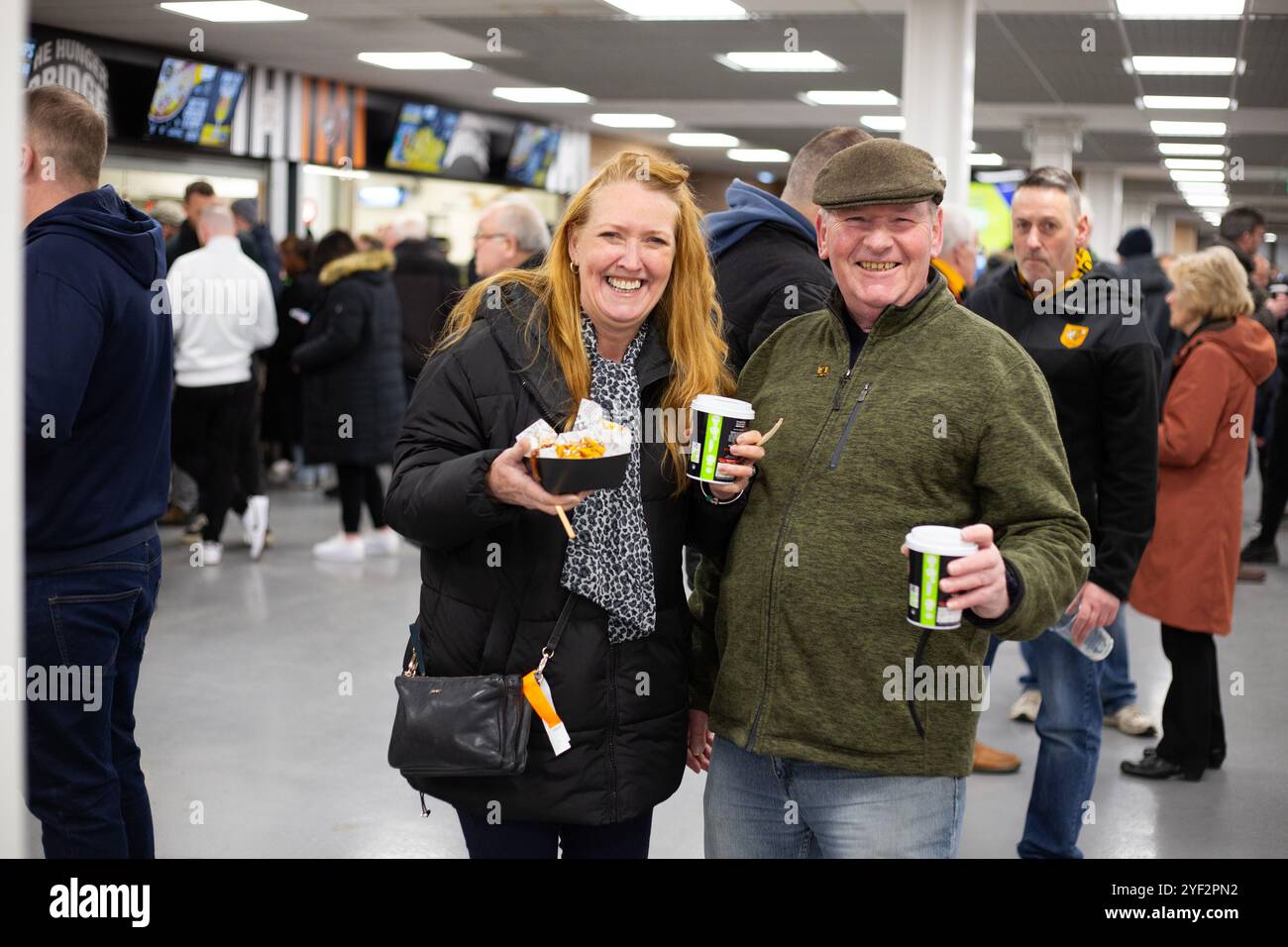 Happy supporters on the concourse head to their seats with food and ...