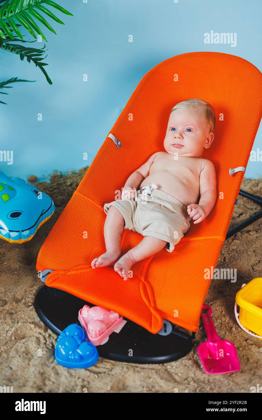 A baby is lying on a recliner chair for babies. Children's recreation ...