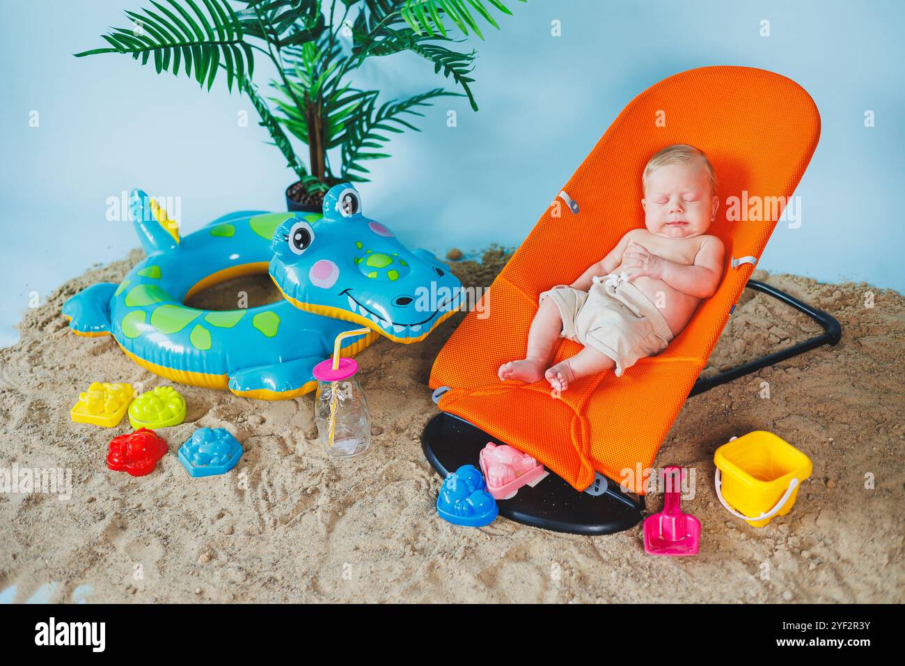 A baby is lying on a recliner chair for babies. Children's recreation ...
