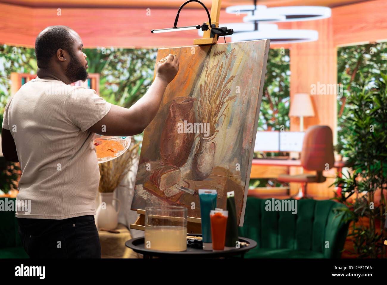 Male artist painting a modern artwork with watercolor and palette ...