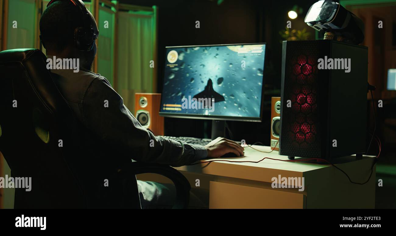 Gamer in neon lit apartment home shooting meteorites in spaceship ...