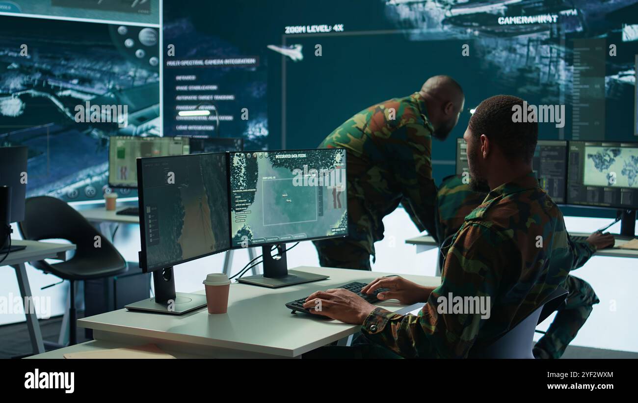 Military personnel in a high tech command center monitor satellite ...