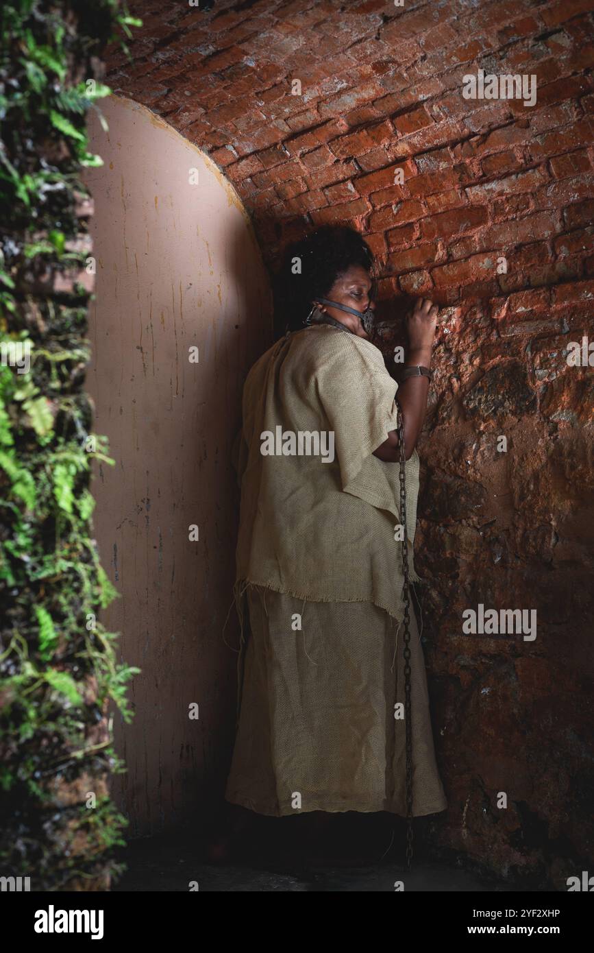 Black woman chained and with an iron mask stuck in her mouth, standing ...