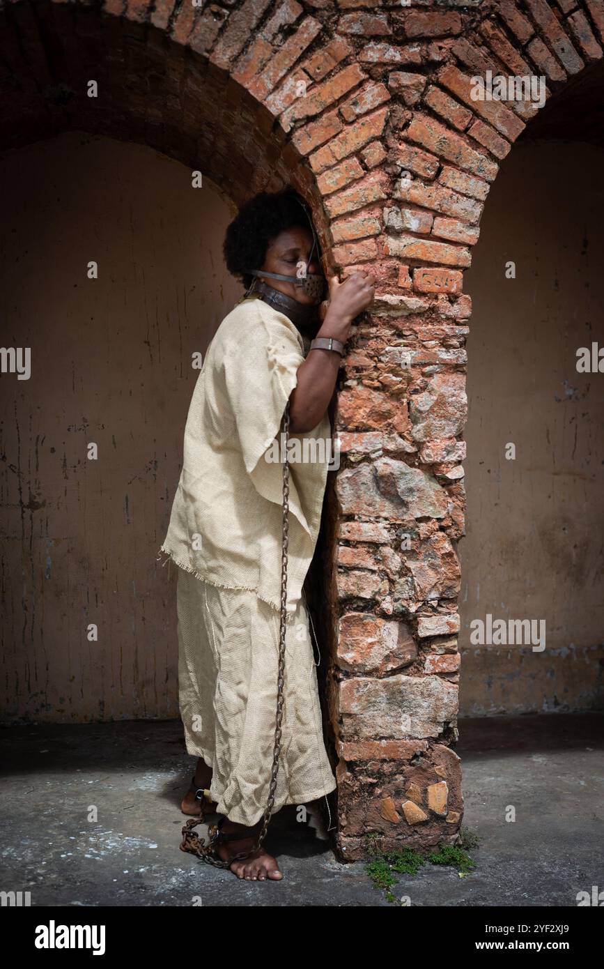 Black woman chained and with an iron mask stuck in her mouth, standing ...