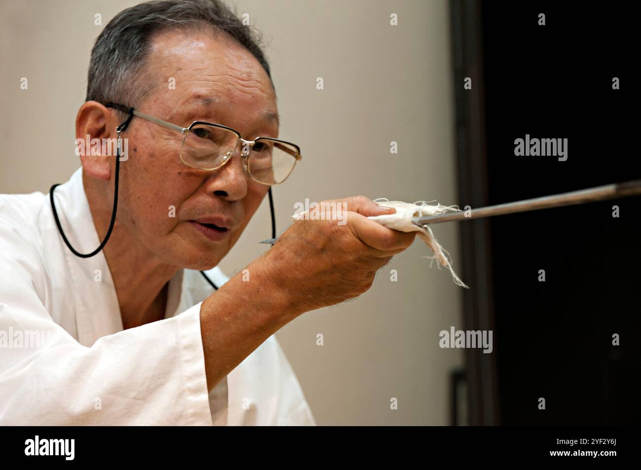 Man sharpening a short Japanese sword called a "wakizashi" in the ...