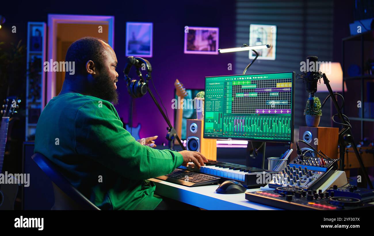 African american audio technician using piano synthesizer keys to add ...