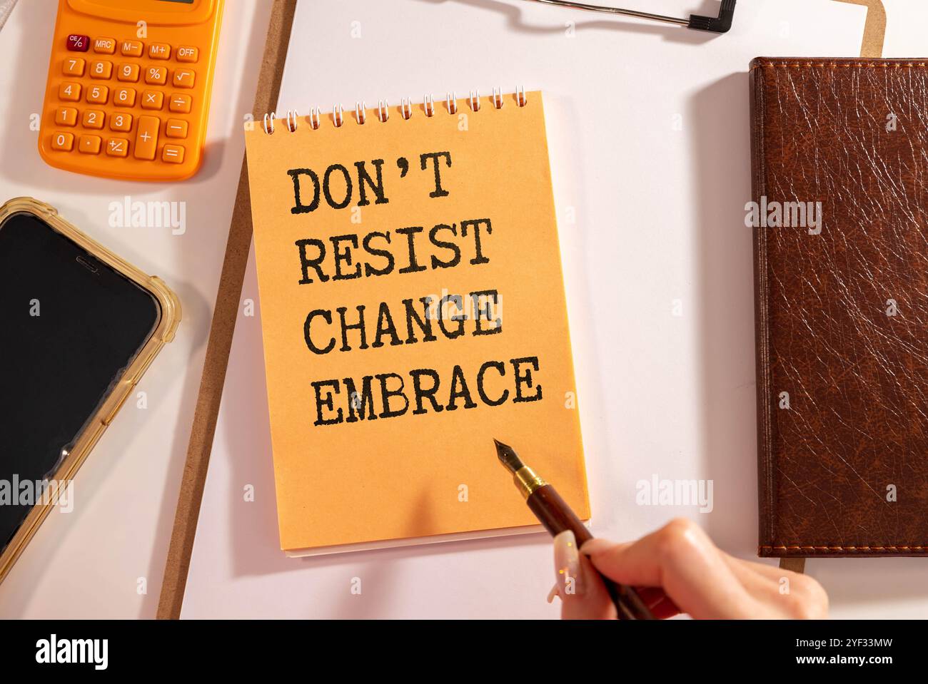 Notepad with text DON'T RESIST CHANGE EMBRACE . White background ...