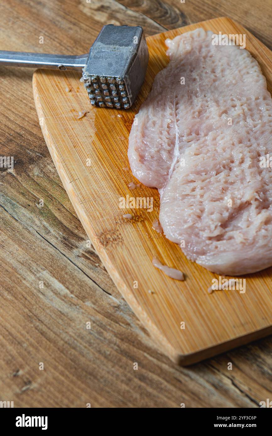 pounding a fillet with a hammer for a diet lunch Stock Photo - Alamy
