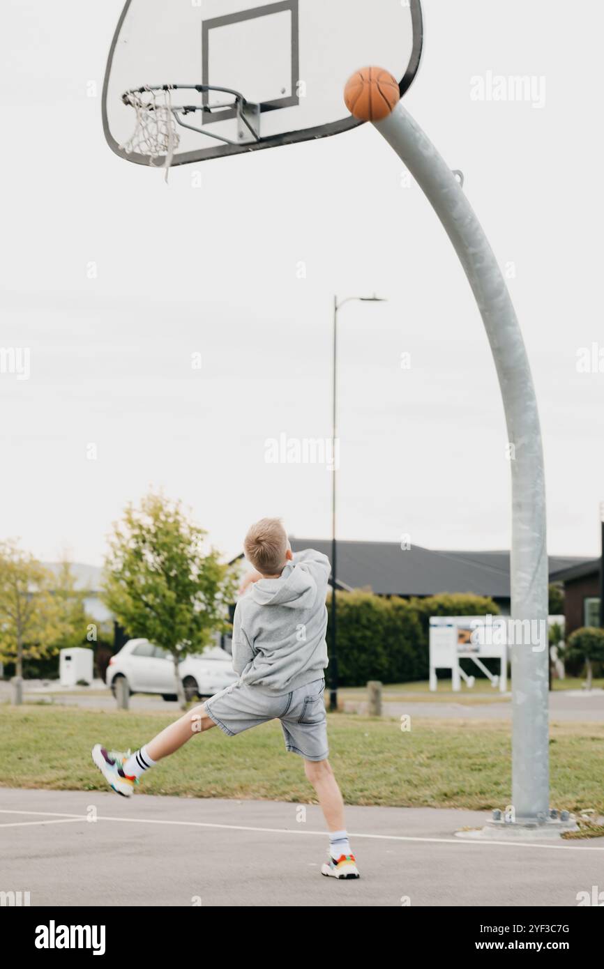 Teenage boy hits goal playing basketball on village sports ground Stock ...