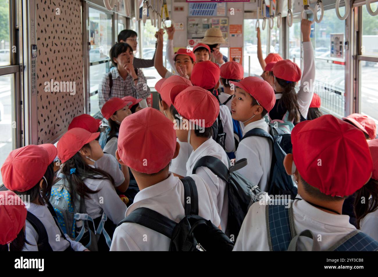 Group of elementary school children wearing matching red caps riding ...