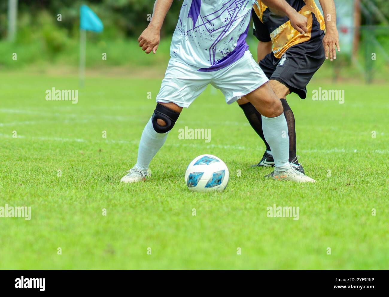 Competitive football players tackling the ball on the field Stock Photo ...