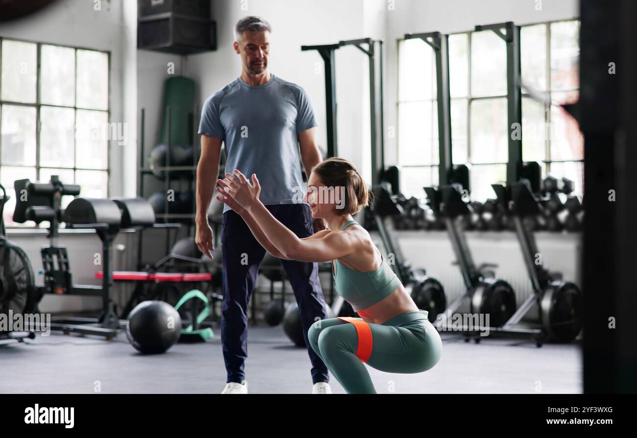 Personal Trainer Showing Glutes Workout With Stretch Bands In Gym Stock ...