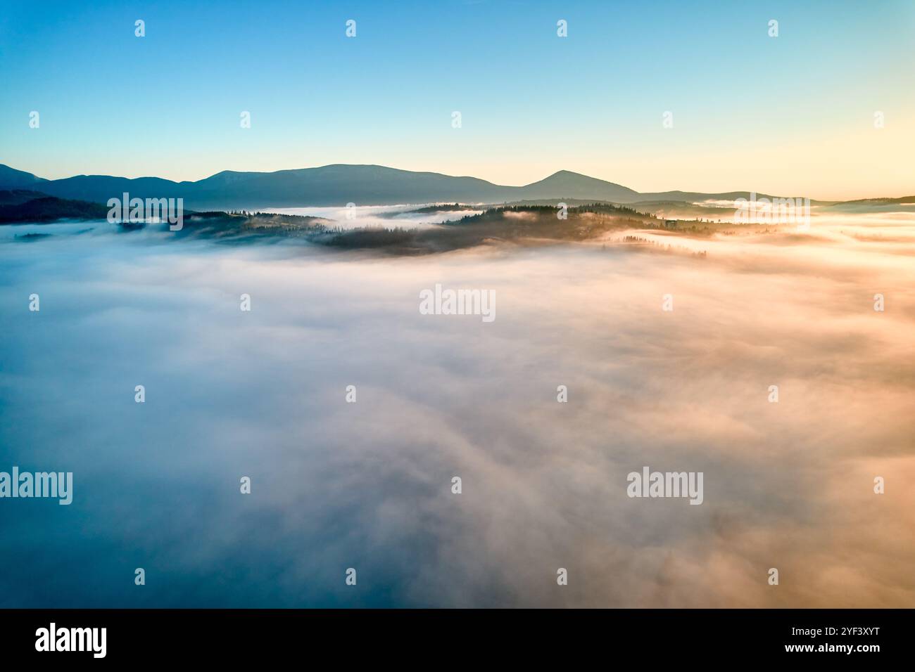 Stunning aerial view of sunrise over mountainous landscape, with thick ...
