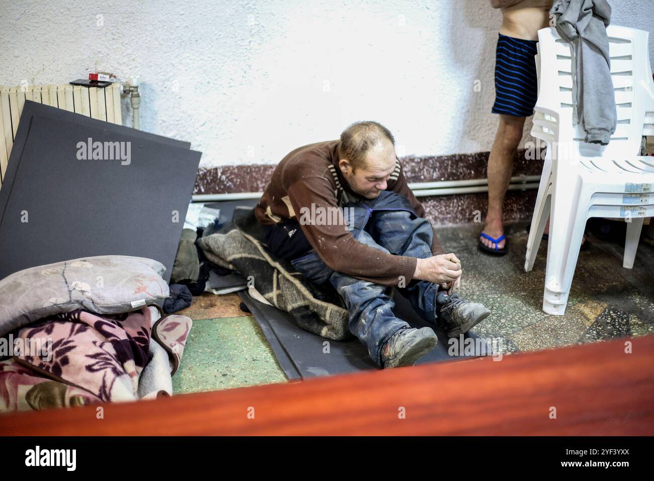 Odessa, Ukraine. 01st Nov, 2024. A man is sitting on the floor in a low ...