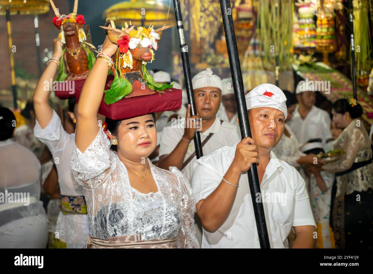 A woman carrying bull-fish statue offering on her head at Kuningan ...