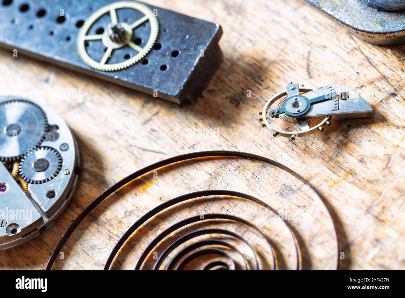 Various containers, tools, and watch components are positioned on the ...