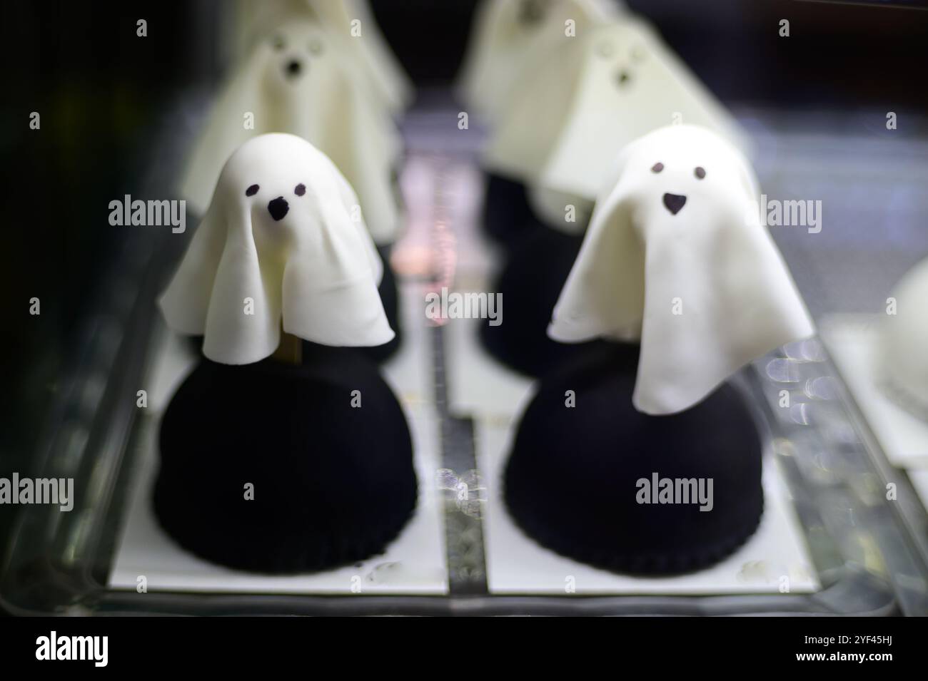 Cute ghost desserts crafted with white icing and dark bases await eager ...