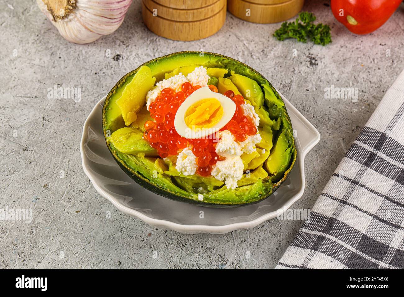 Avocado with red caviar and quil egg and soft cheese Stock Photo - Alamy