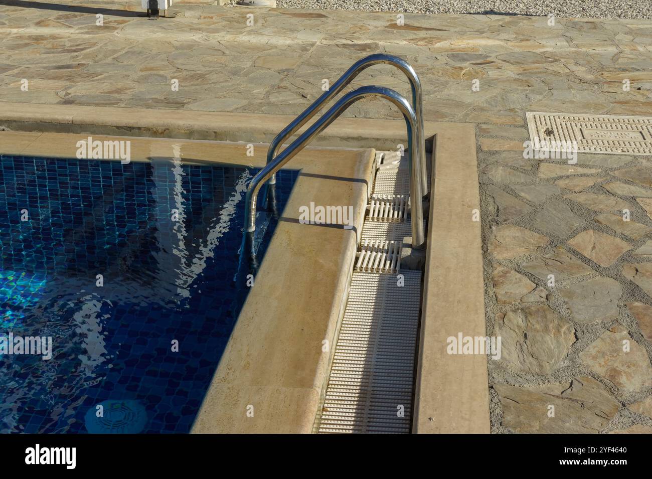 The sun reflects off the clear water as the gleaming ladder awaits ...