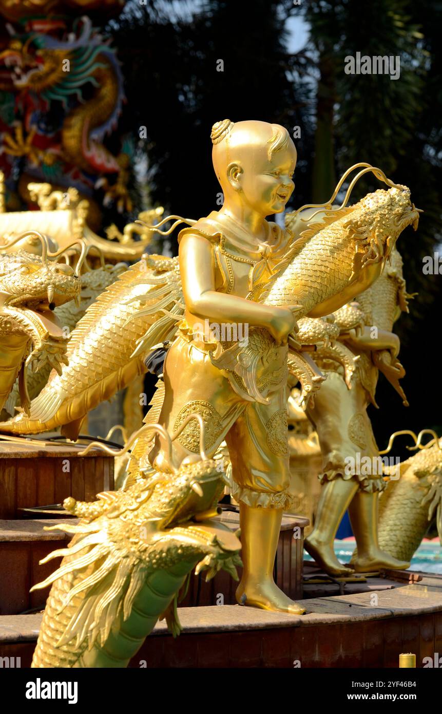 The golden statue of a child holding a fish represents abundance ...