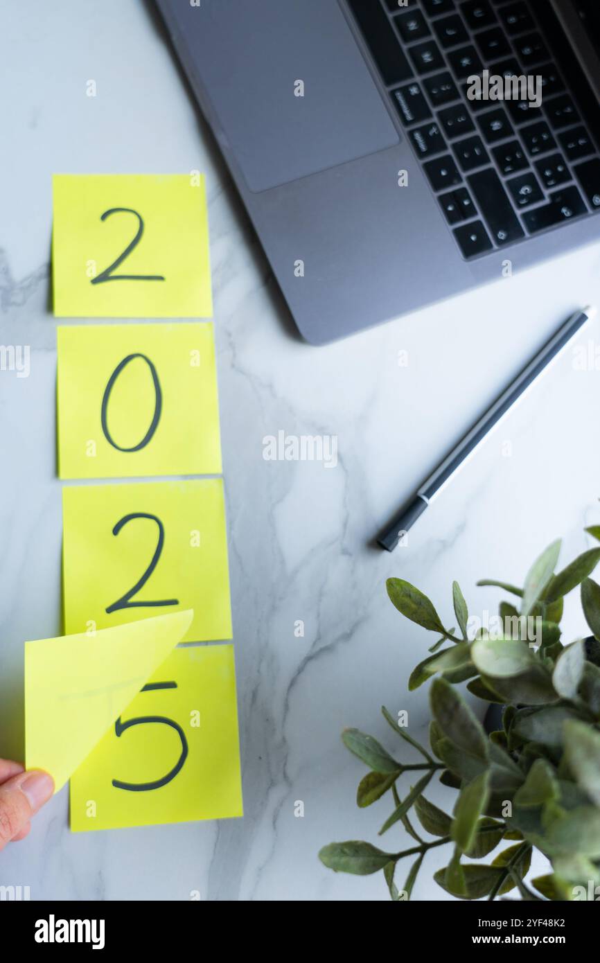 Post It with the numbers 2025 of the new year next to a laptop. Step ...