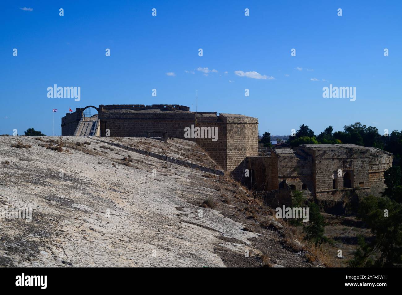 Majestic stone structures stand resilient on a rocky slope, bathed in ...