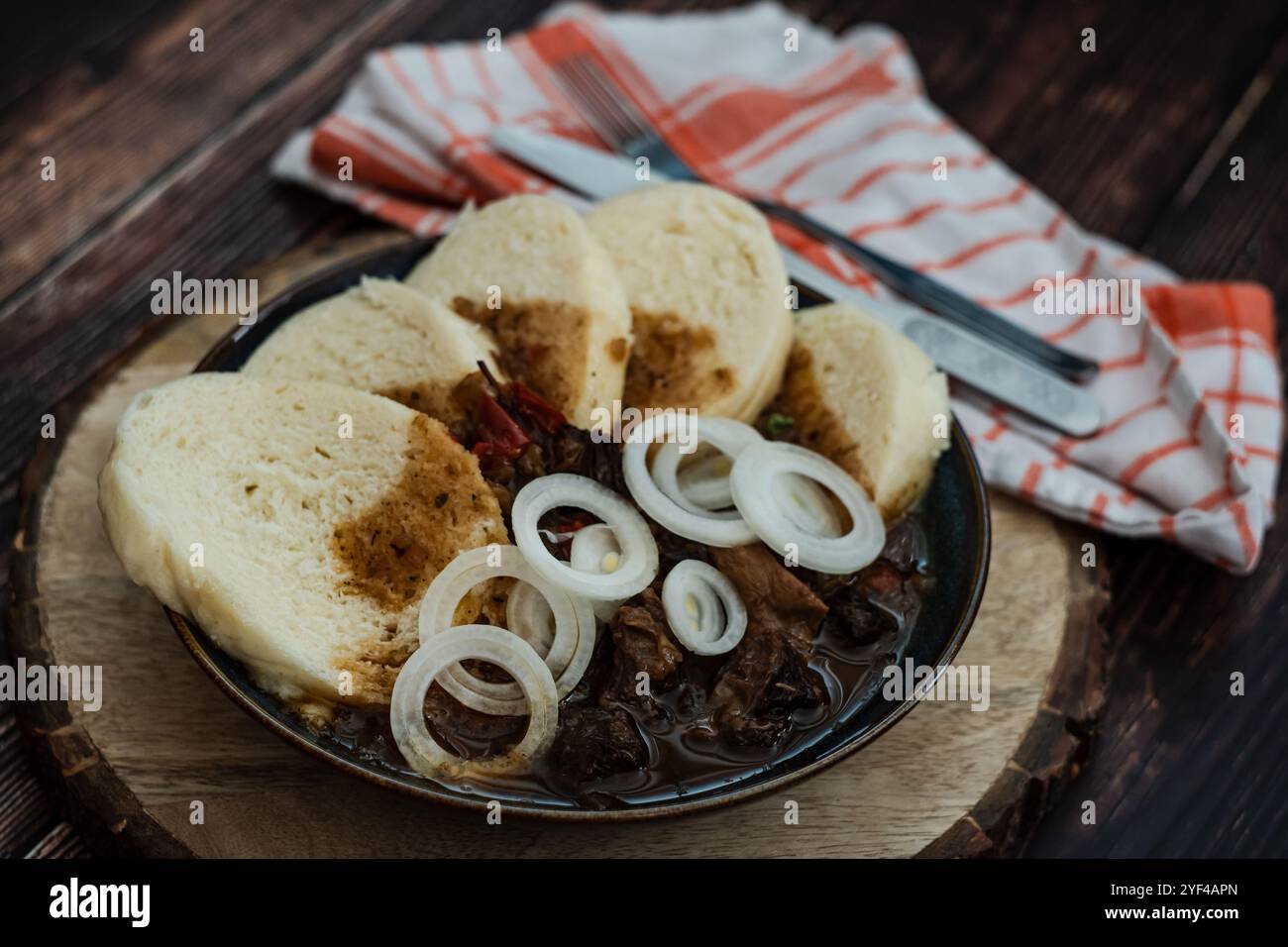 The scene features a traditional Czech beef goulash served with bread ...
