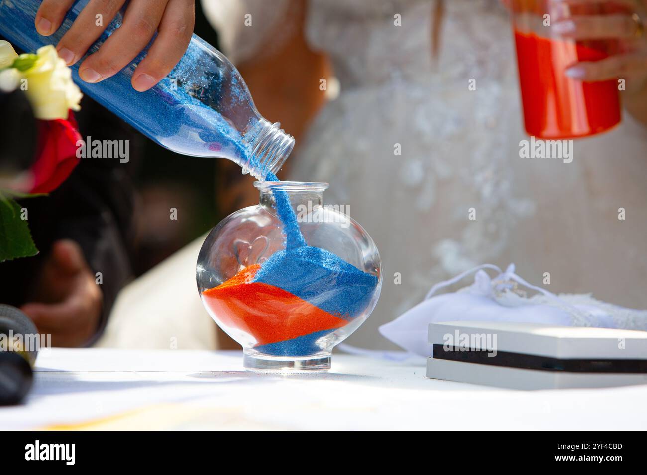Bride and groom performing the sand ceremony ritual, pouring blue and ...
