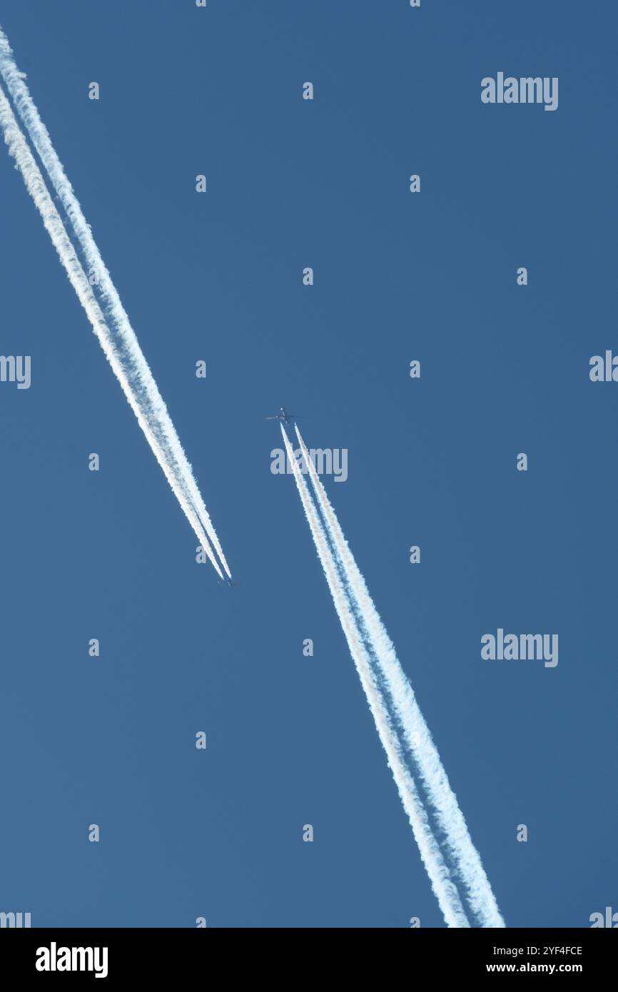 Airplane trails in the blue sky, contrails Stock Photo - Alamy