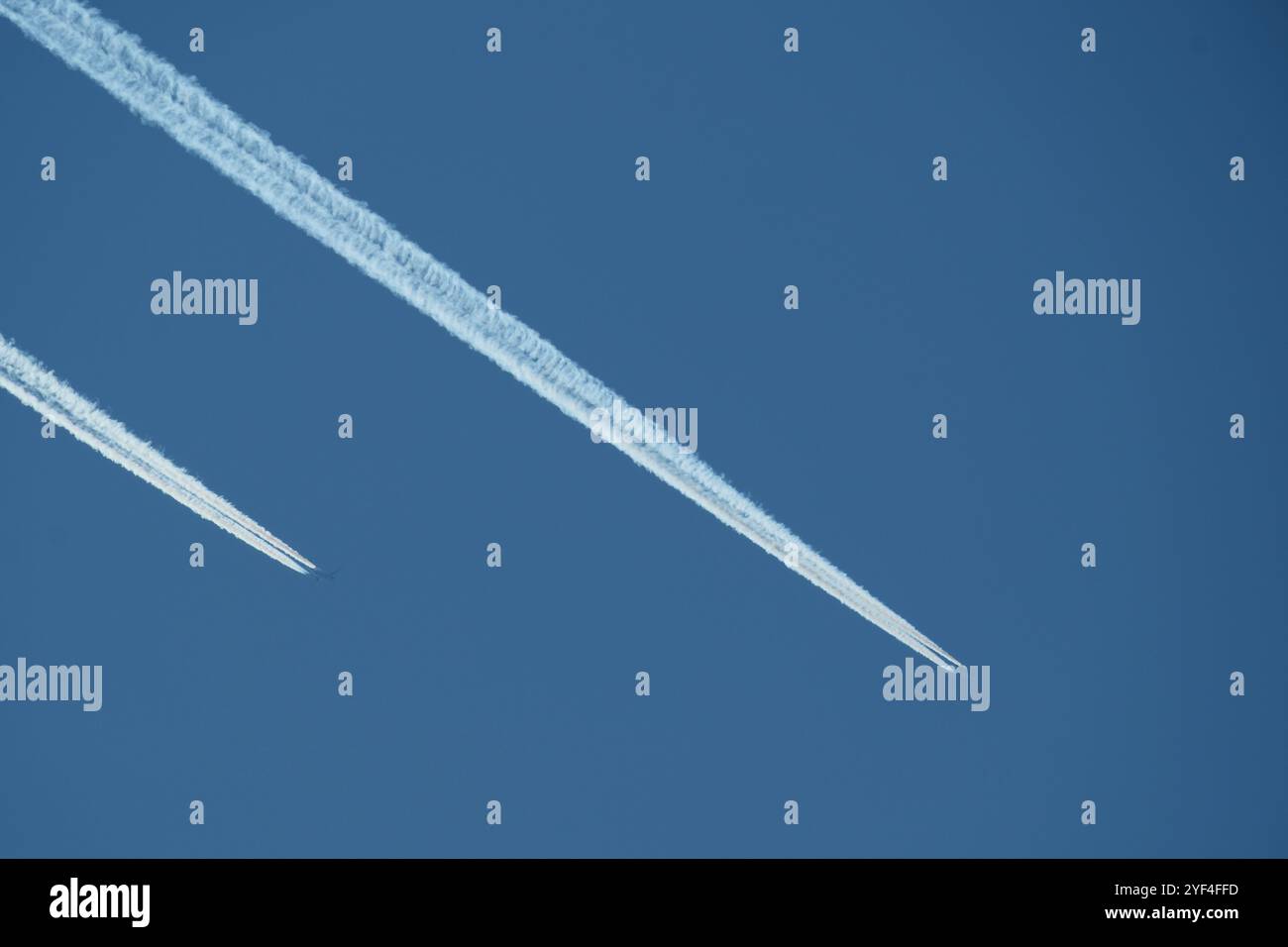 Airplane trails in the blue sky, contrails Stock Photo - Alamy