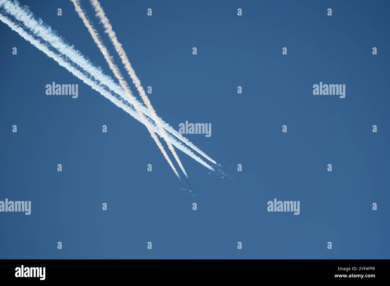 Airplane trails in the blue sky, contrails Stock Photo - Alamy