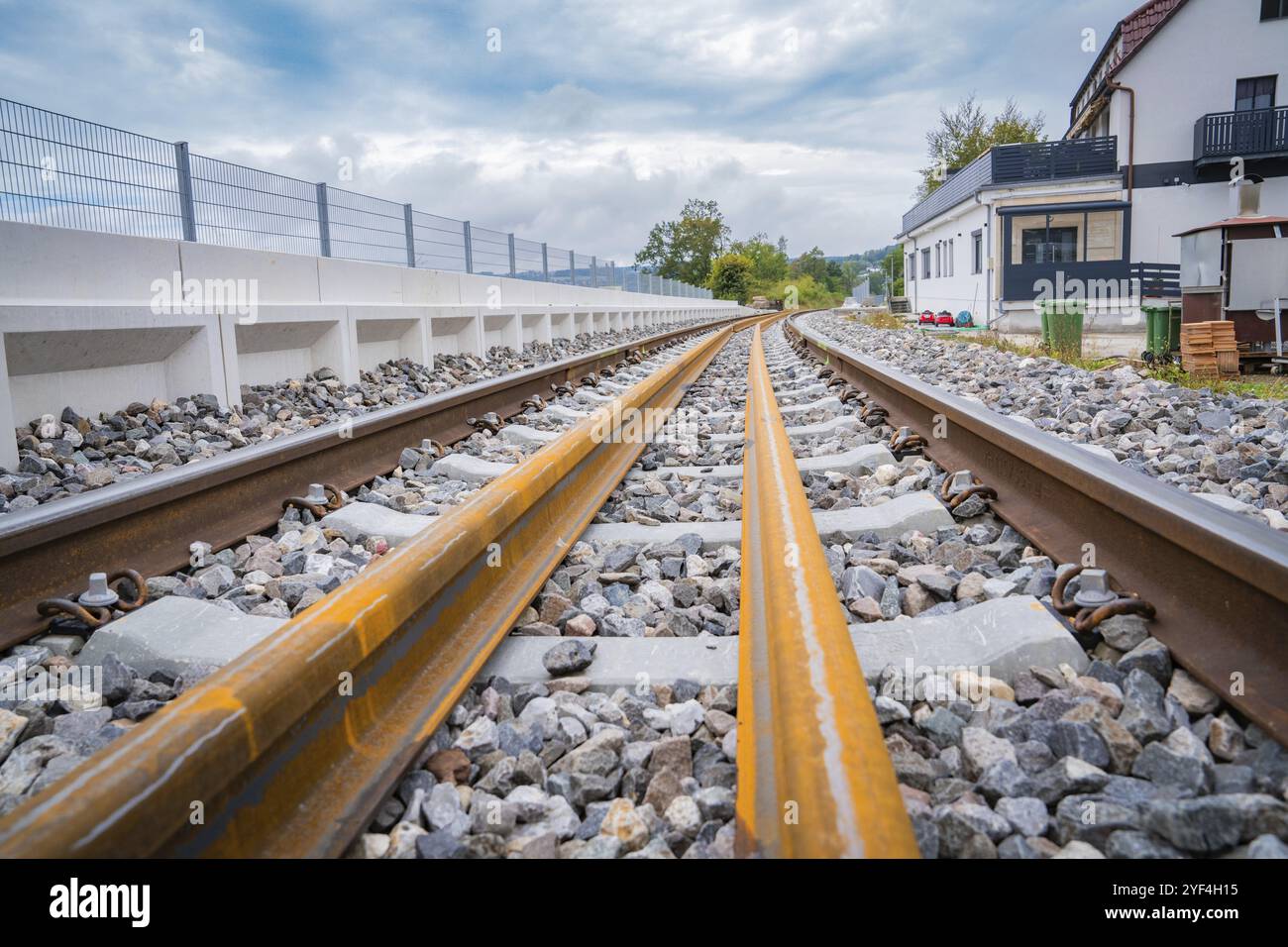 A railway track runs through a landscape with buildings in the ...