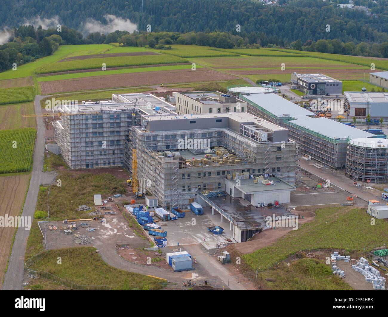 Bird's eye view of a building under construction, surrounded by fields ...