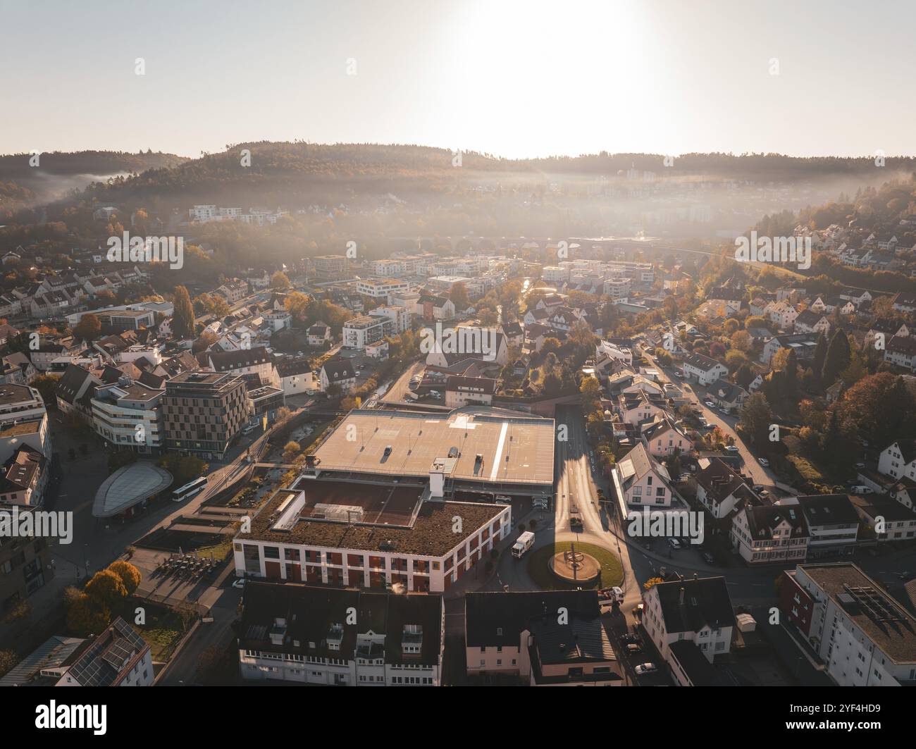 A town in daylight with surrounding hills and buildings in autumn ...