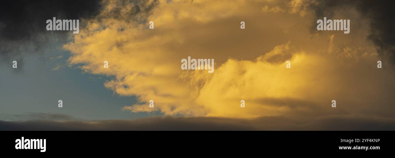 Panorama dramatic clouds illuminated rising of sun floating blue sky ...