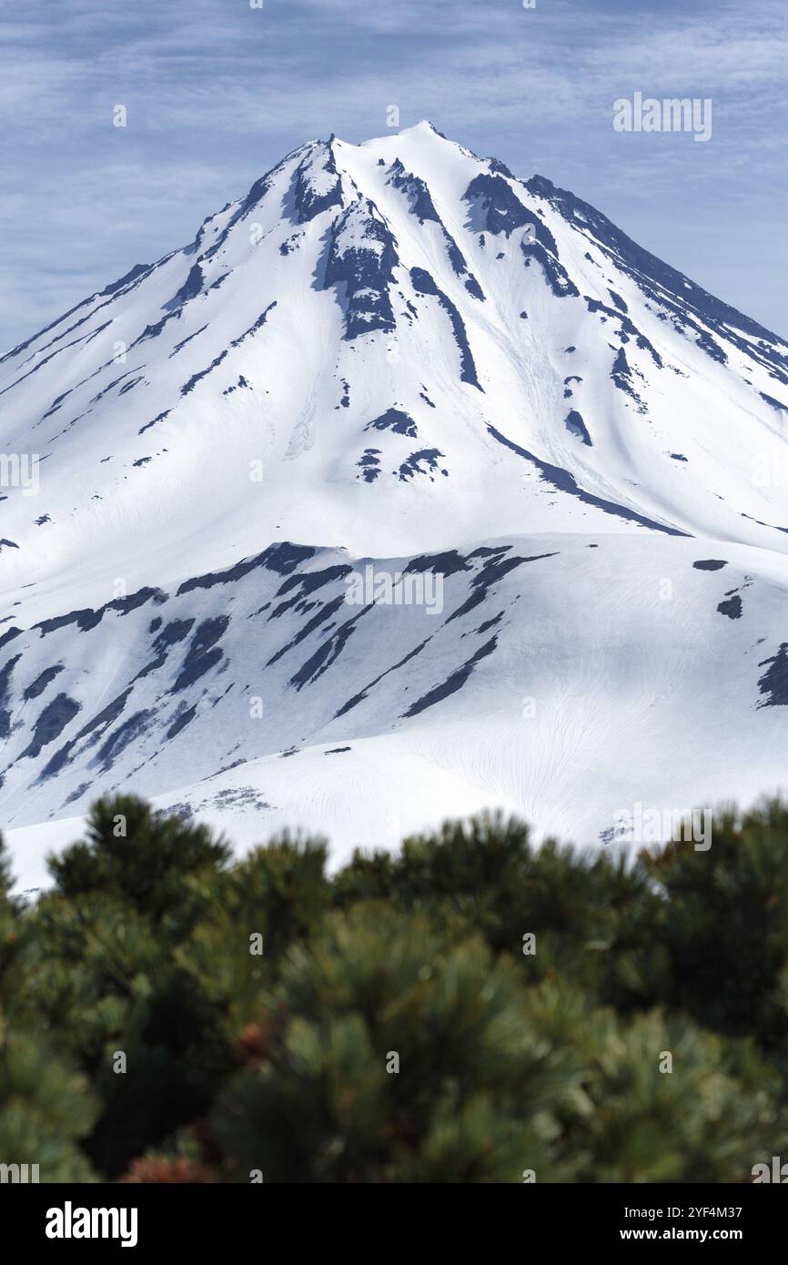 Volcanic landscape of Kamchatka Peninsula: view of snow-capped cone of ...