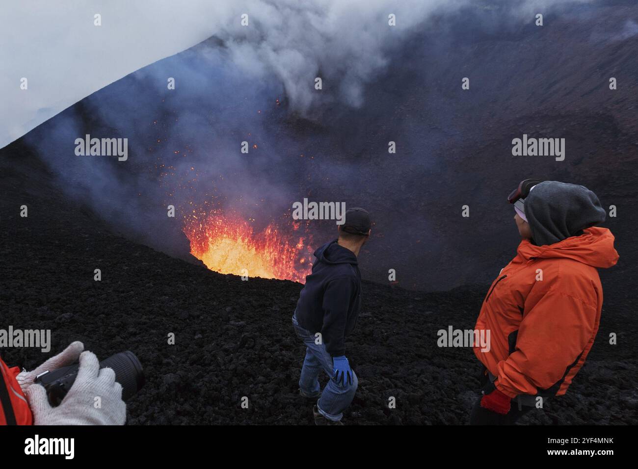 Tourists watching the beautiful volcanic eruption, standing on the ...