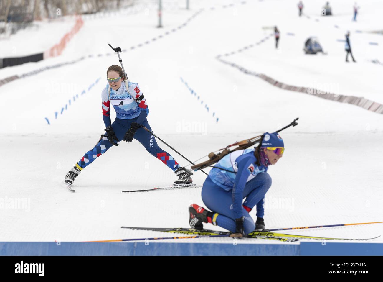 Two sportswoman biathletes at finish line after skiing and rifle ...