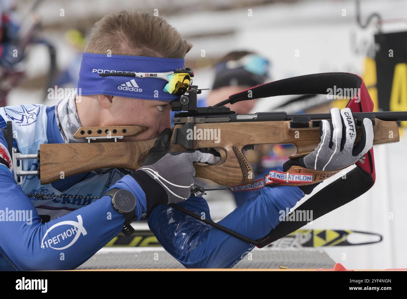 Sportsman biathlete rifle shooting, aiming, reloading rifle in prone ...