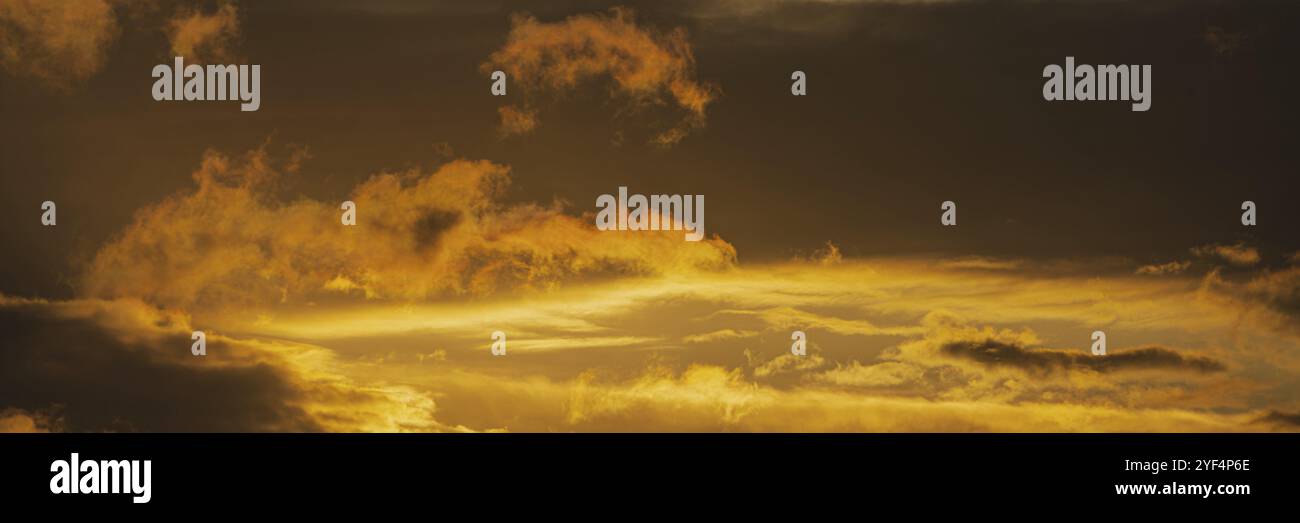 Panorama dramatic clouds illuminated rising of sun floating in sky to ...