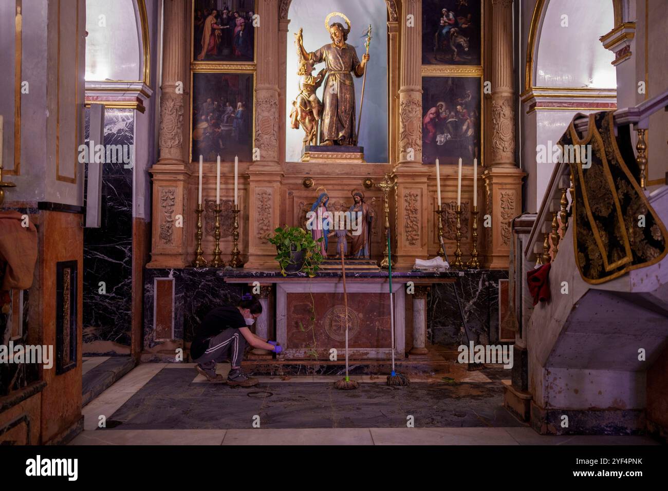A woman cleans religious items in the Basilica of Saint James the ...