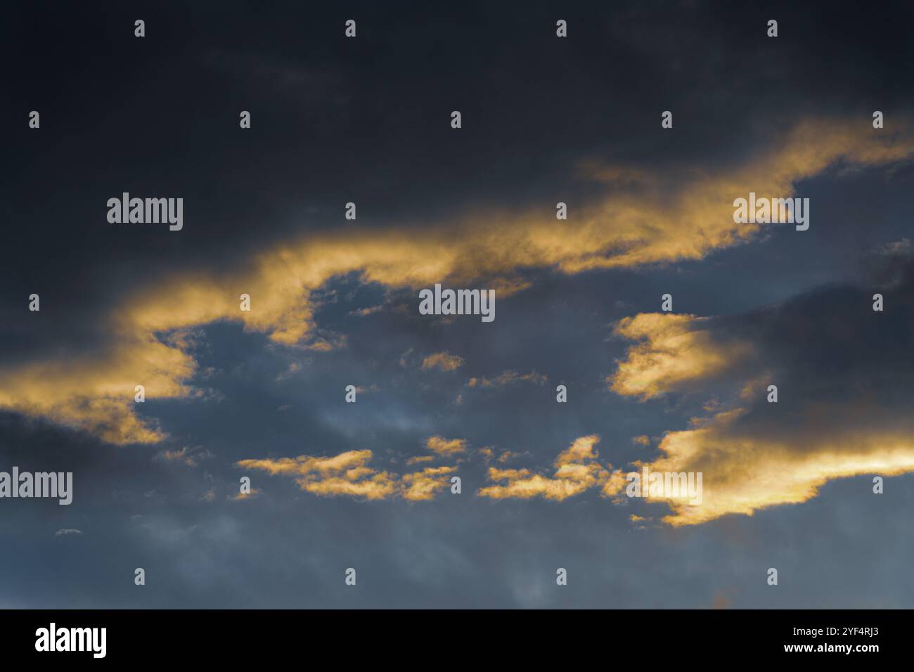 Fluffy thunderstorm clouds illuminated by disappearing rays at sunset ...
