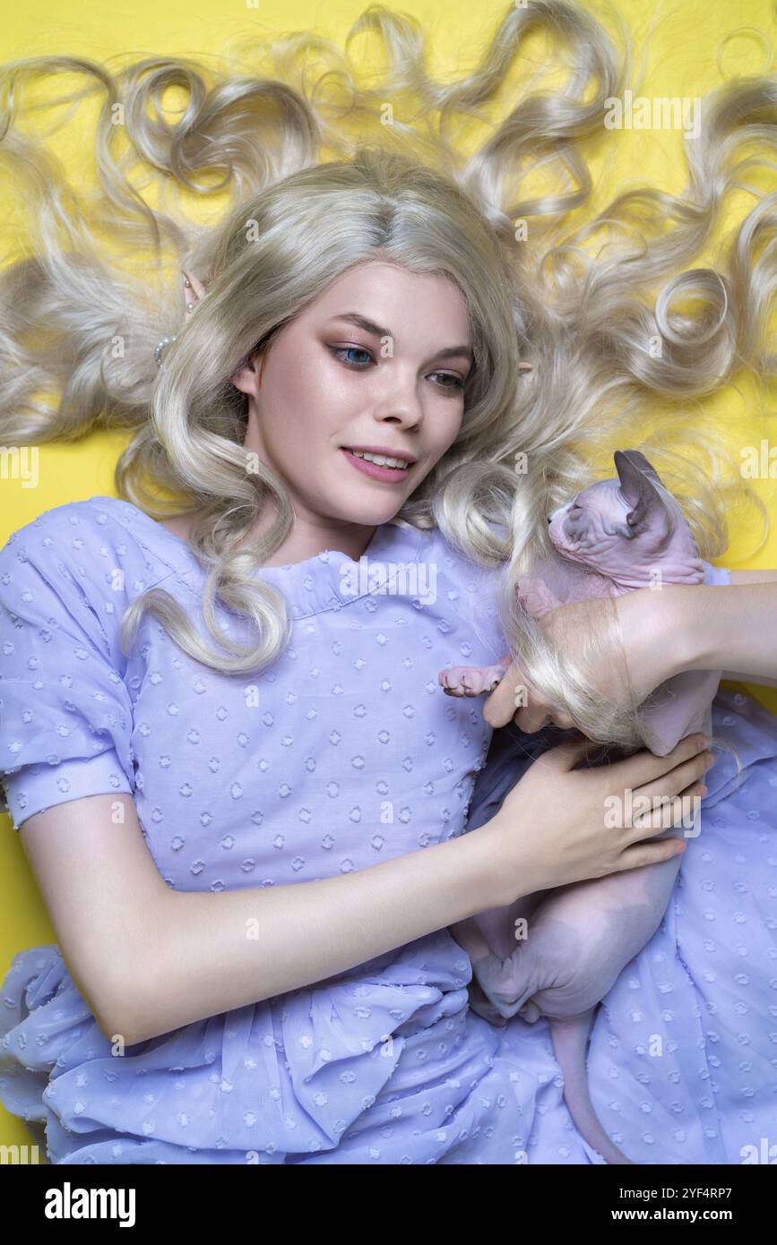 Cosplayer elf young blonde woman in summer blue dress lying down on ...