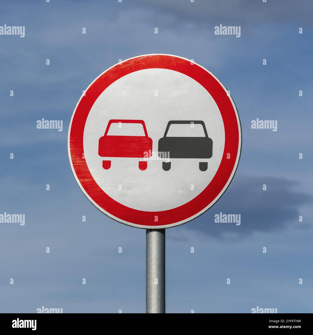 No overtaking road traffic sign on background of blue sky with clouds ...