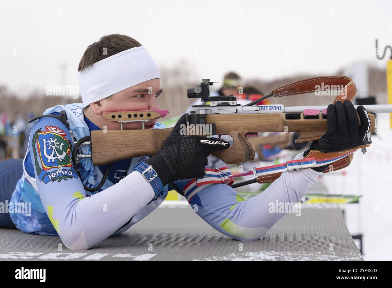 Sportsman biathlete aiming rifle shooting prone position. Biathlete ...