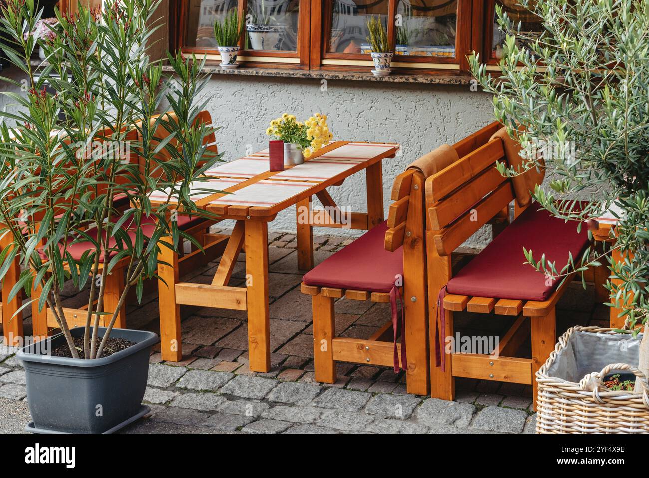 Street terrace of the coffee shop. Wooden tables for two next to the ...